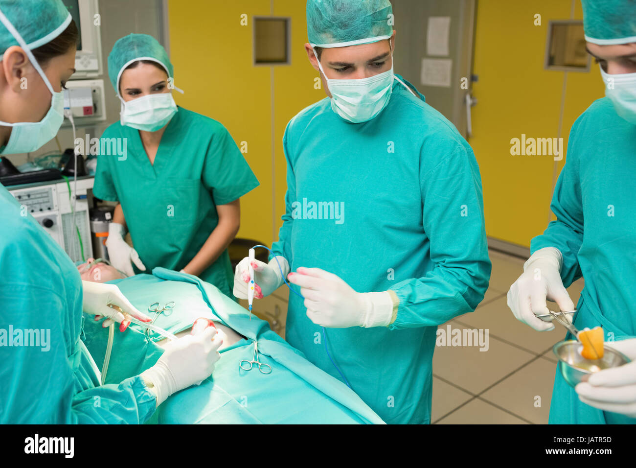 Surgeons next to a patient in an operating theatre Stock Photo - Alamy