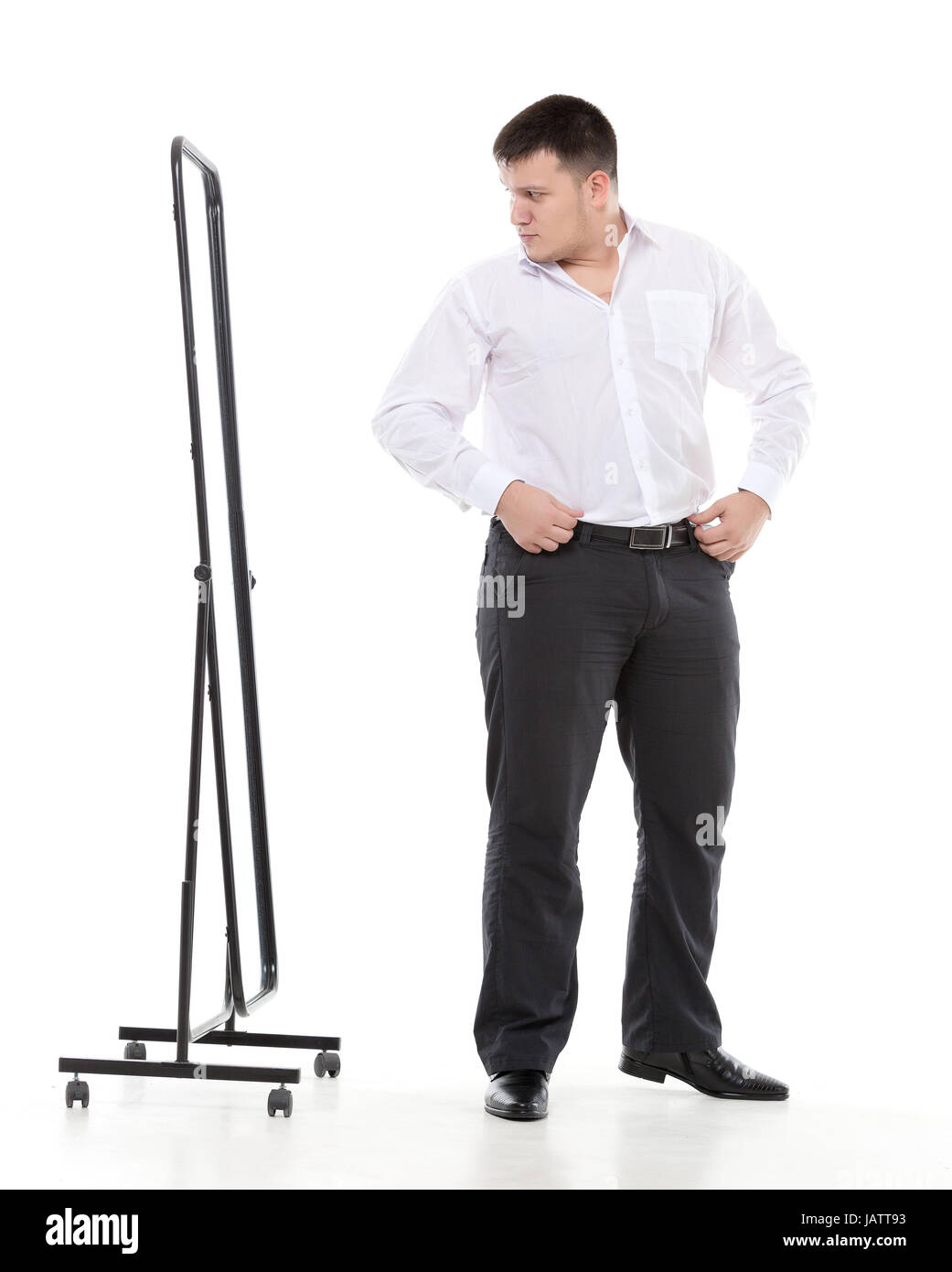 Overweight man admiring himself in a standing mirror as he checks the ...