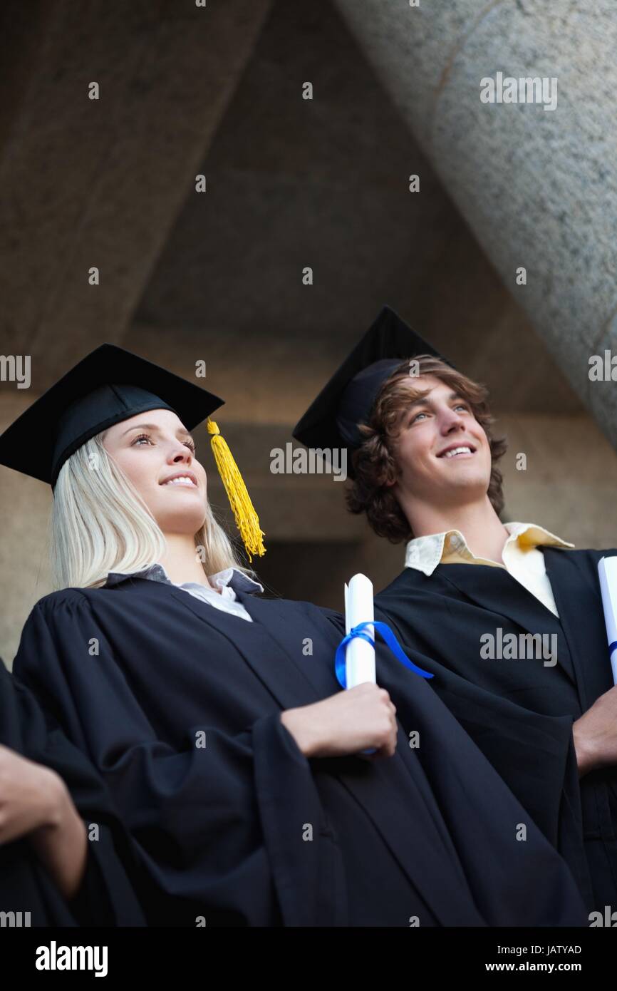 Low-angle view of happy graduating students Stock Photo - Alamy