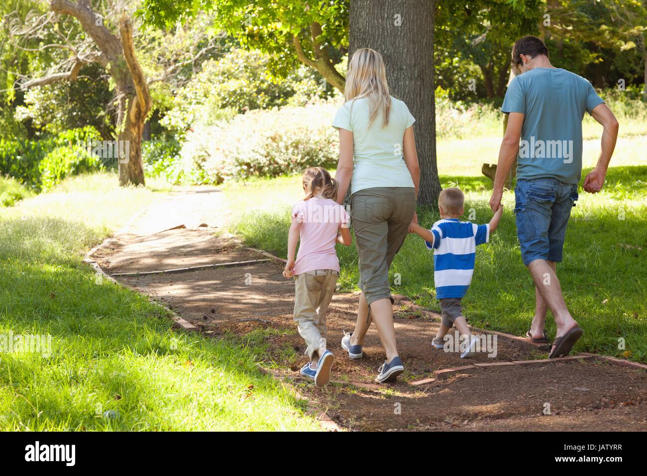 A happy family walking down a path Stock Photo - Alamy