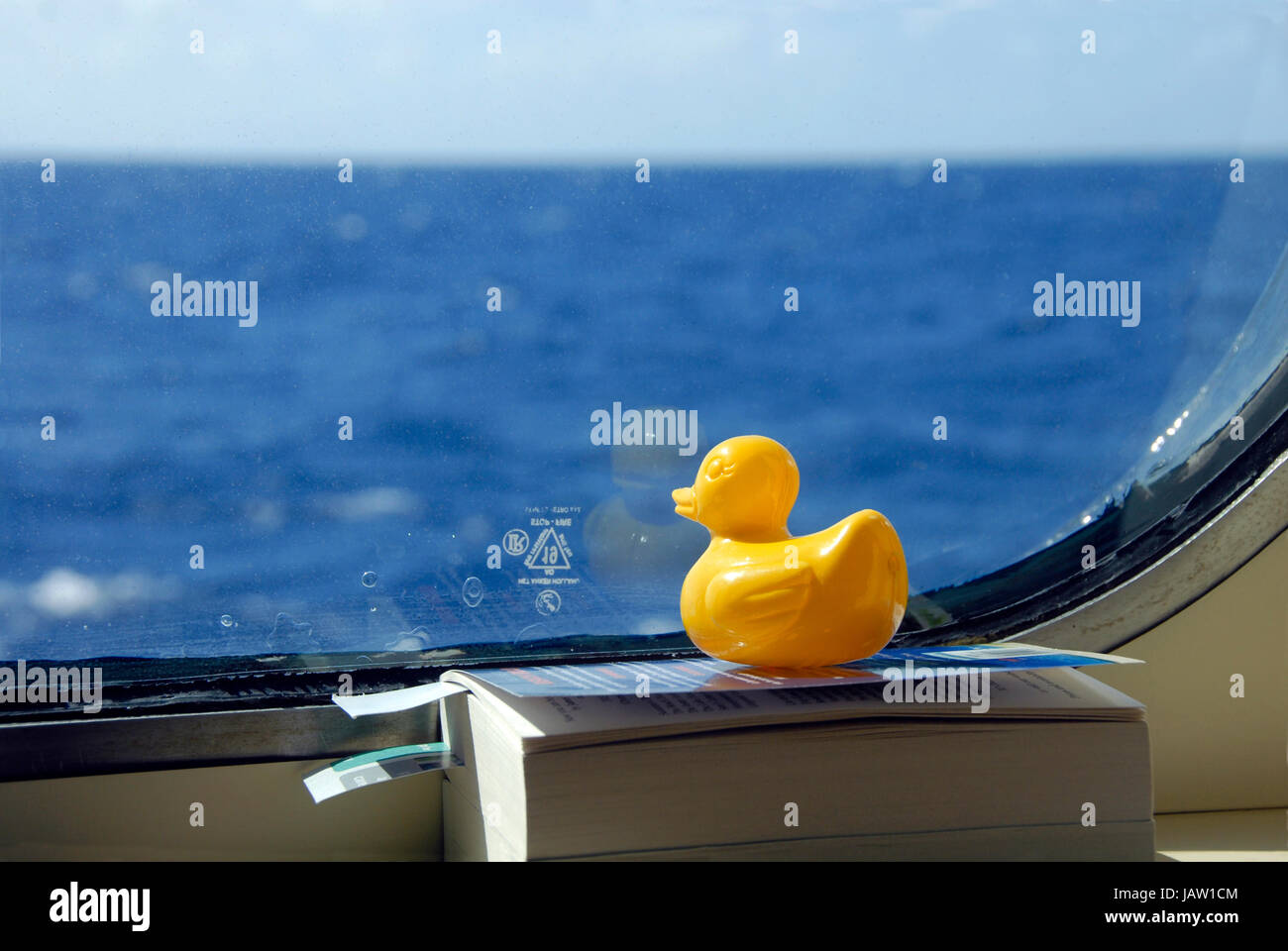 Yellow plastic duck looking at sea through liner cabin window Stock ...