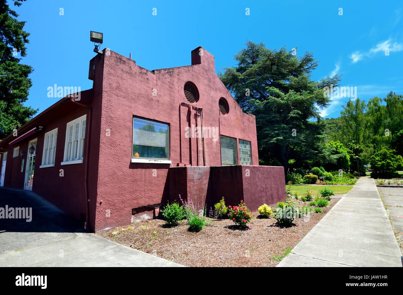 Red Adobe Building With Flower Bed Stock Photo - Alamy