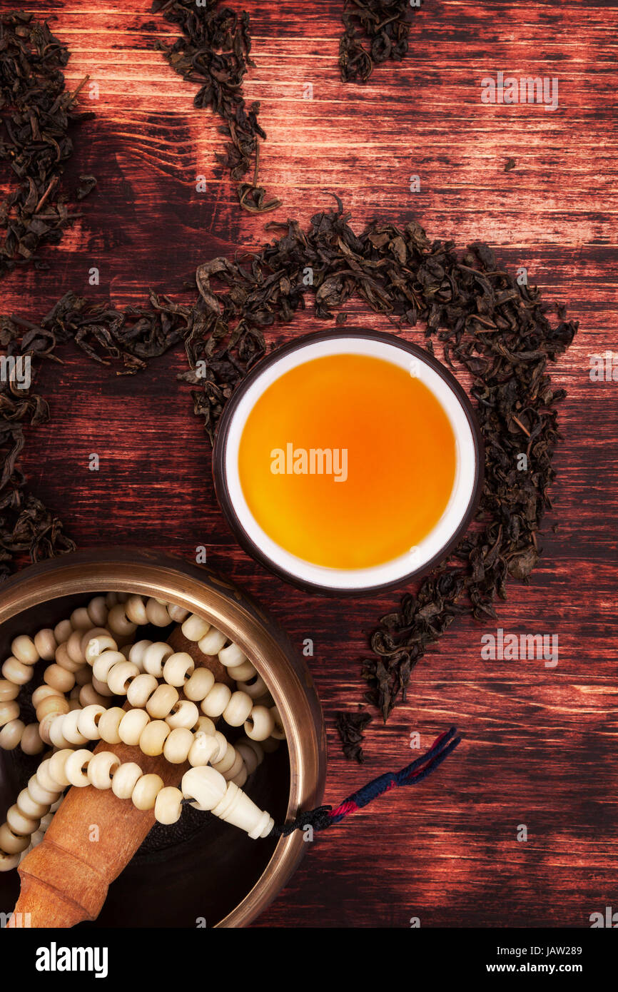 Traditional tea ritual. Tea in cup, dry tea crop forming the ohm symbol ...
