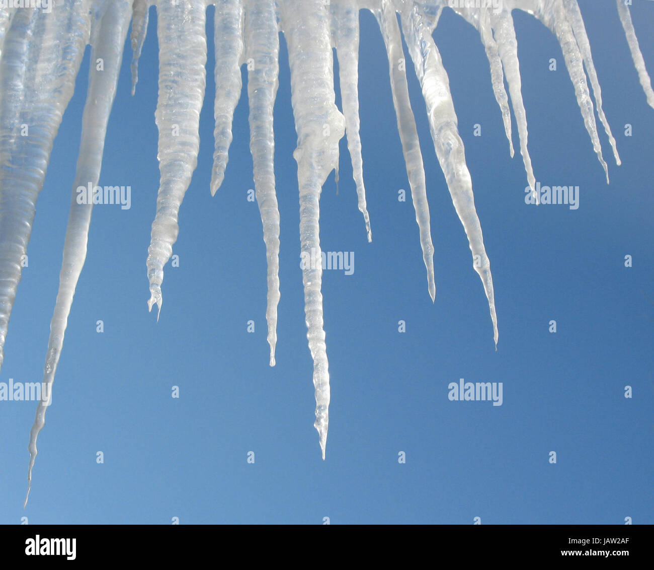 White icicles drop from a blue sky Stock Photo - Alamy