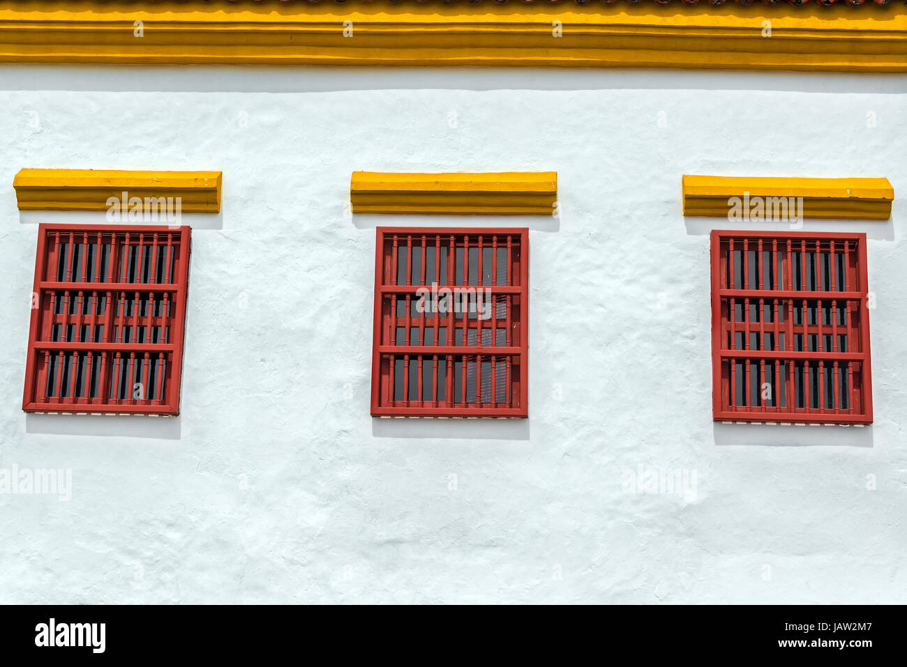 Three red windows on a white historic colonial building the center of ...