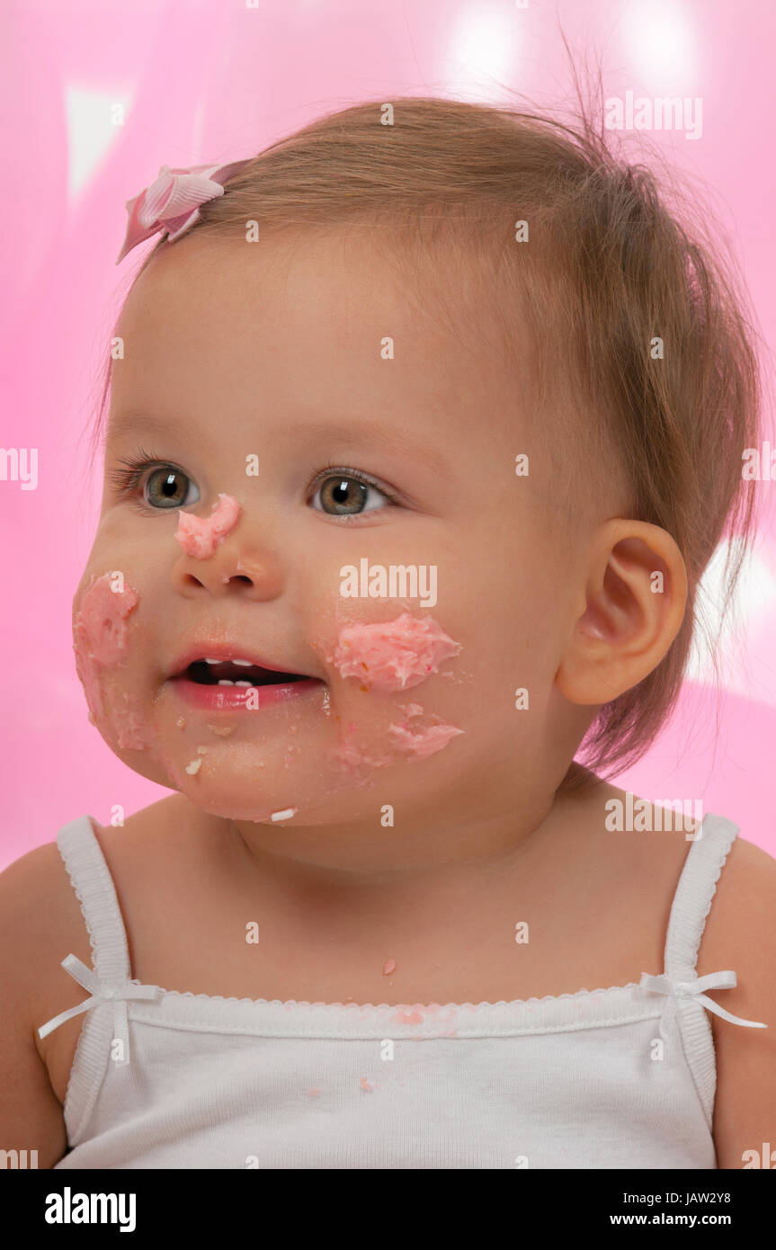 Cute baby girl with cake frosting on her face Stock Photo - Alamy