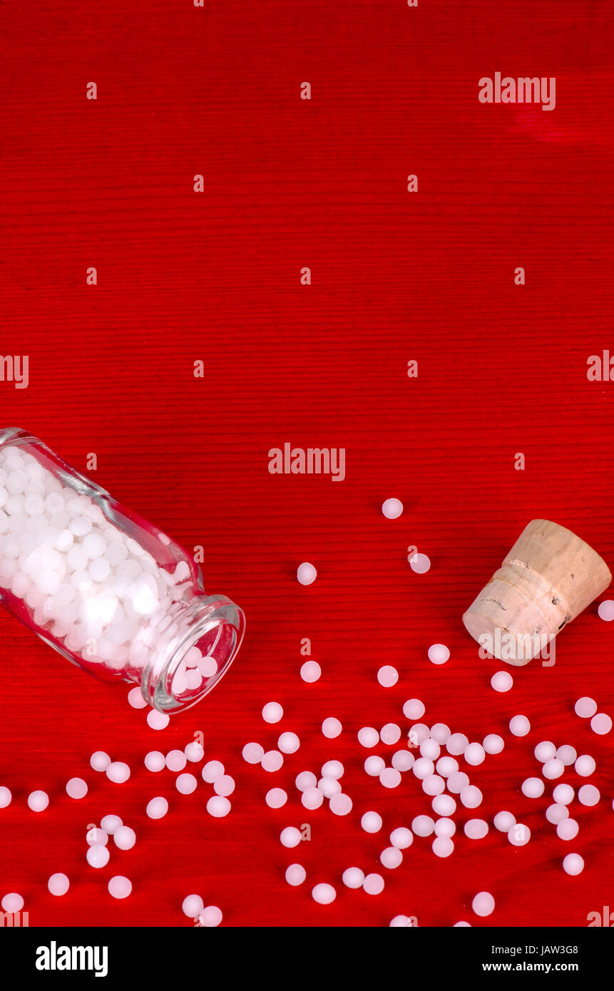 homeopathic globules on a red wooden background Stock Photo - Alamy