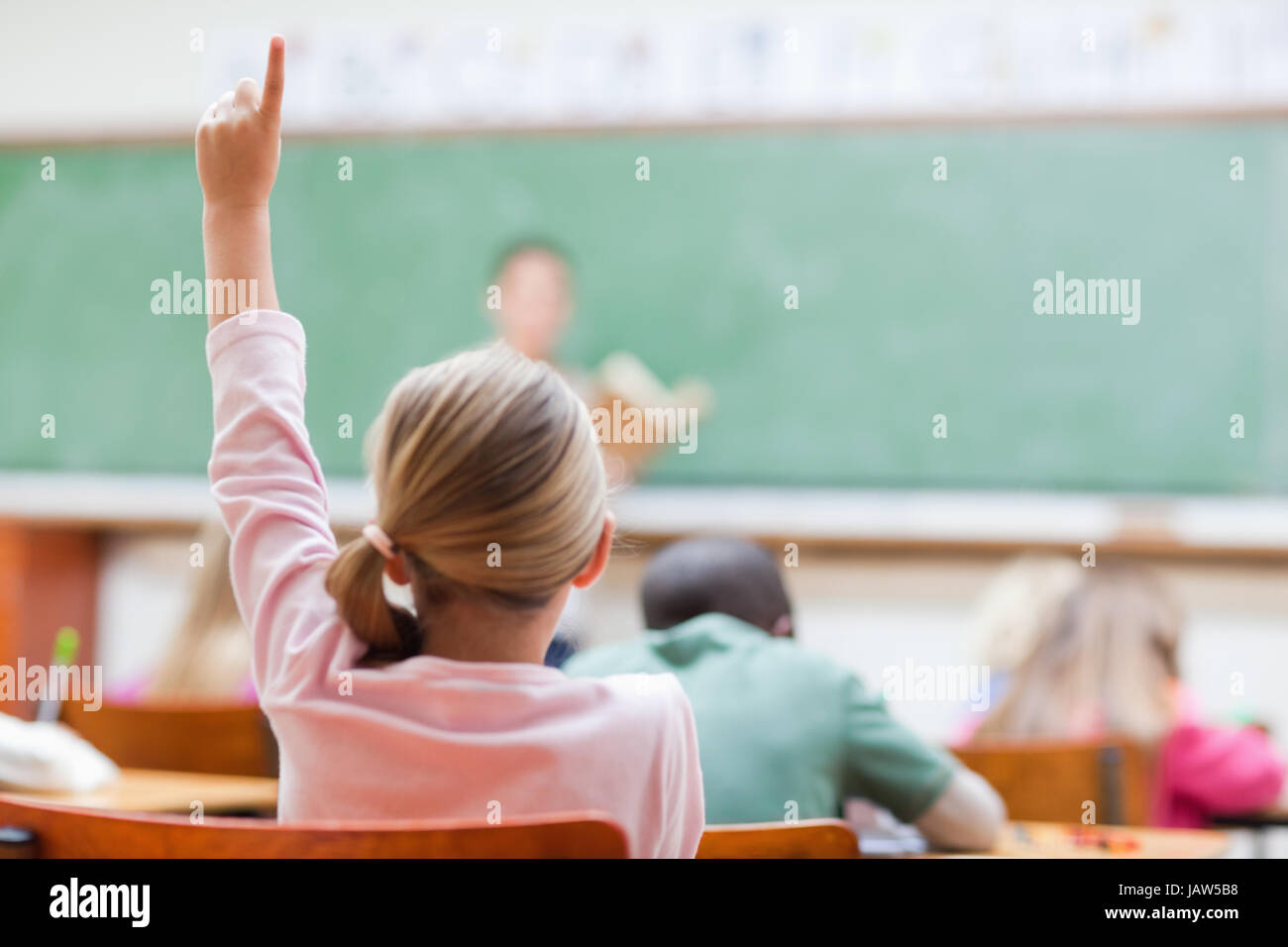 Elementary student raising her hand Stock Photo - Alamy