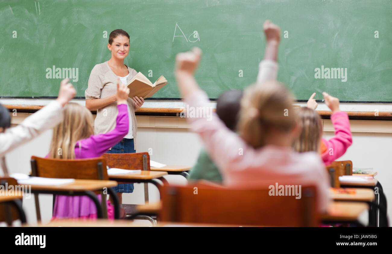 Teacher about to pick one of her students to answer Stock Photo - Alamy