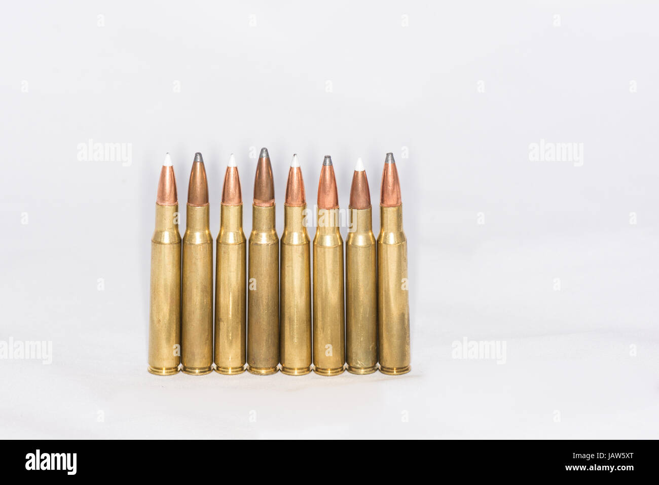 A few rifle bullets lined up in a row on white background Stock Photo ...
