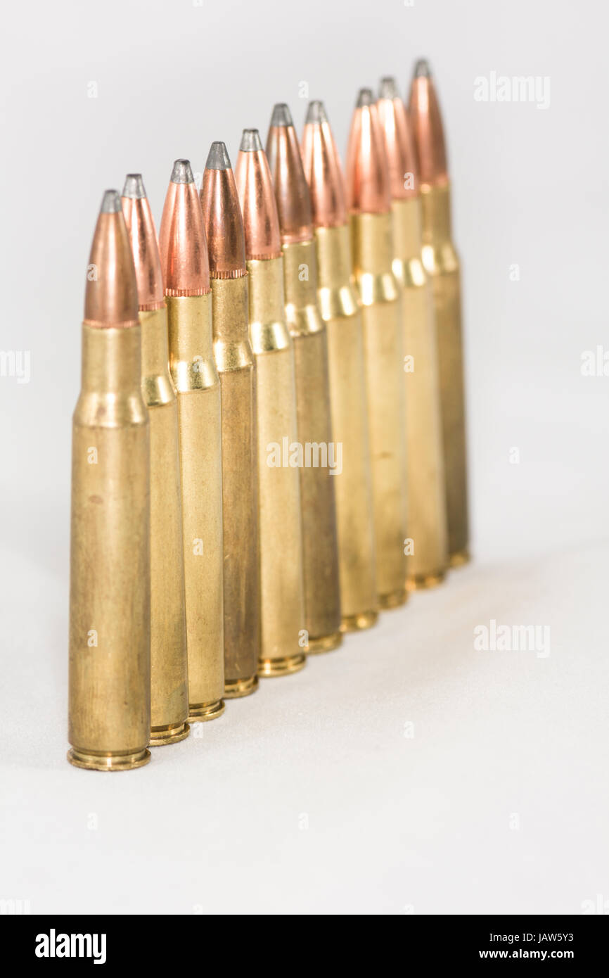 A few rifle bullets lined up in a row on white background Stock Photo ...