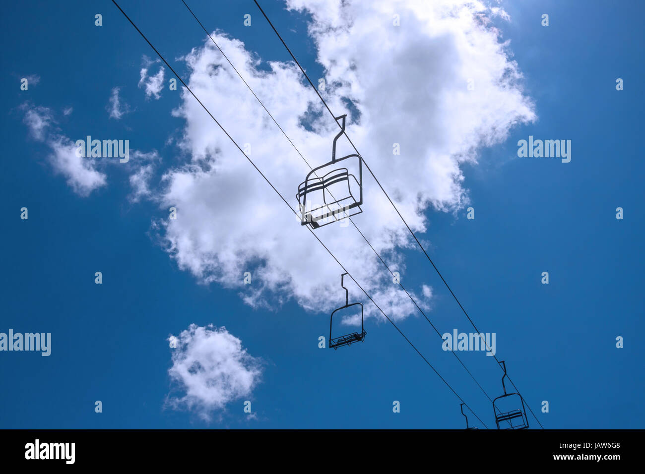 Empty ski lift from below against deep blue sky Stock Photo - Alamy