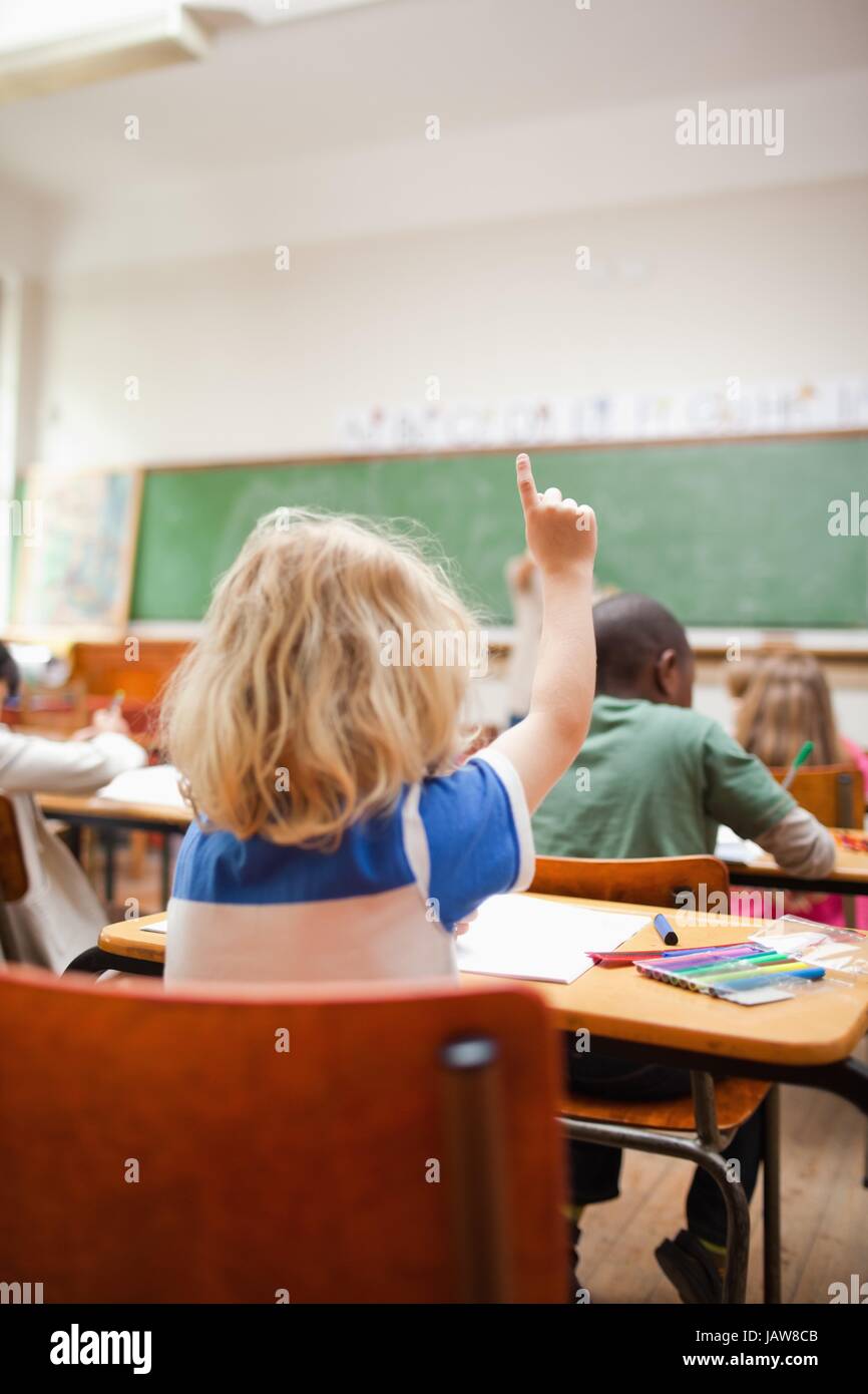 Back view of schoolboy raising hand Stock Photo - Alamy