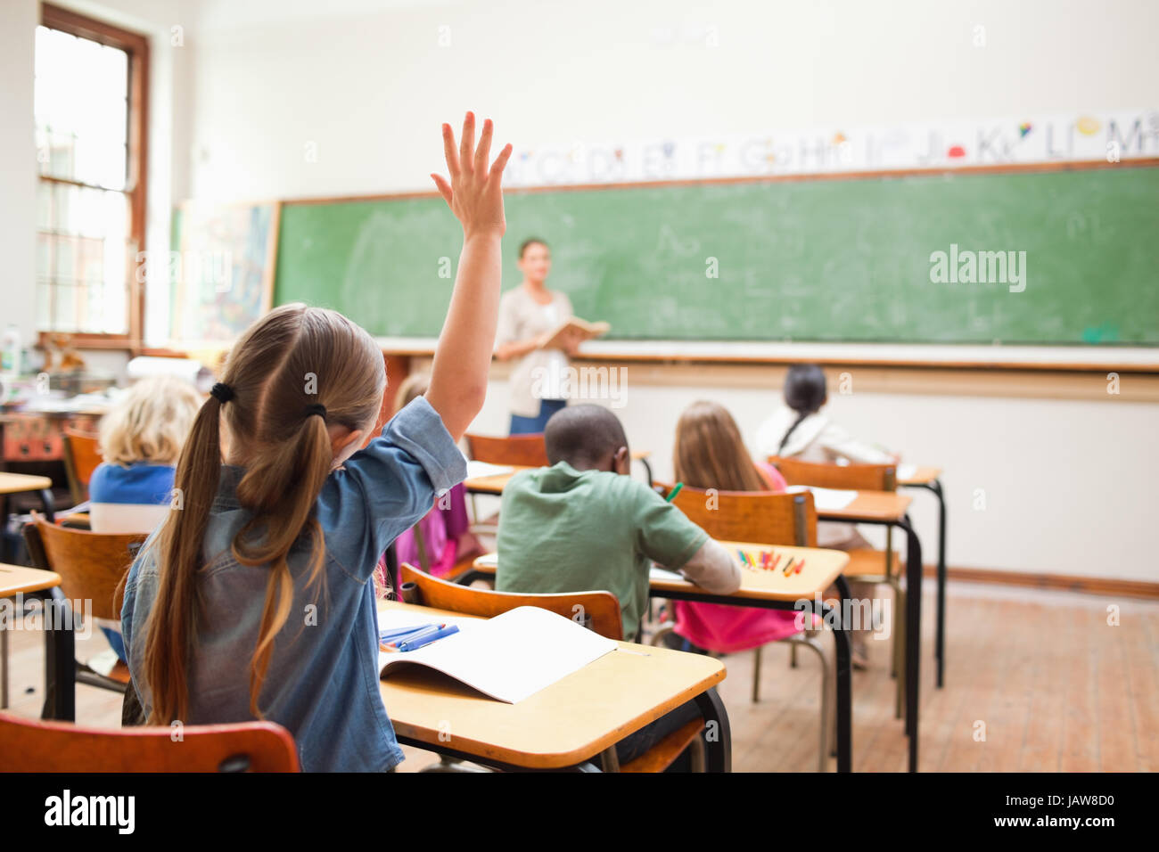 Back view schoolgirl raising hand hi-res stock photography and images ...
