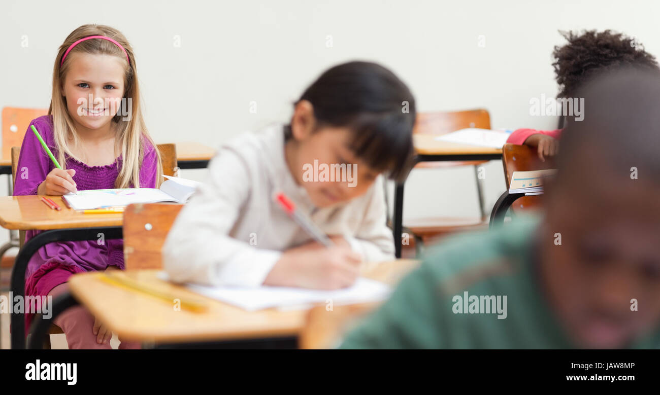 Smiling little girl sitting in class Stock Photo - Alamy