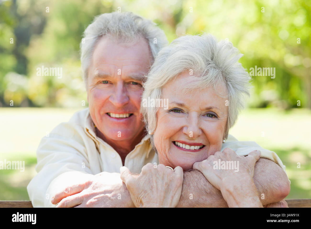 Man putting his arms around his friend in a park Stock Photo - Alamy