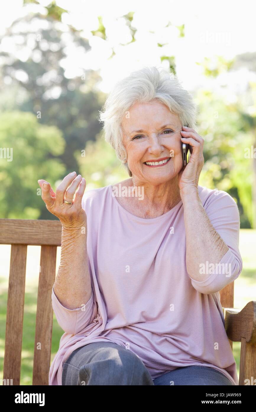 Woman smiling while making a call and performing a hand gesture Stock ...