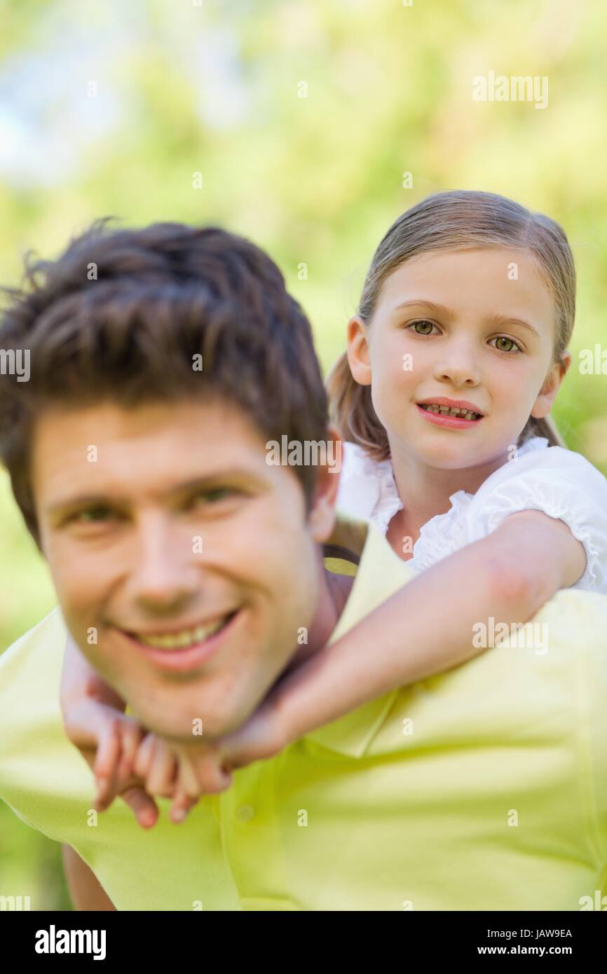 Focus on the girl on her fathers back Stock Photo - Alamy
