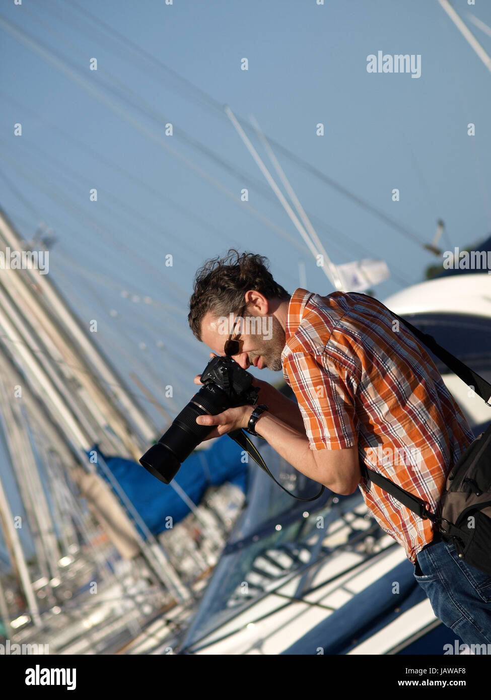 Handsome photographer at work in a harbour Stock Photo - Alamy