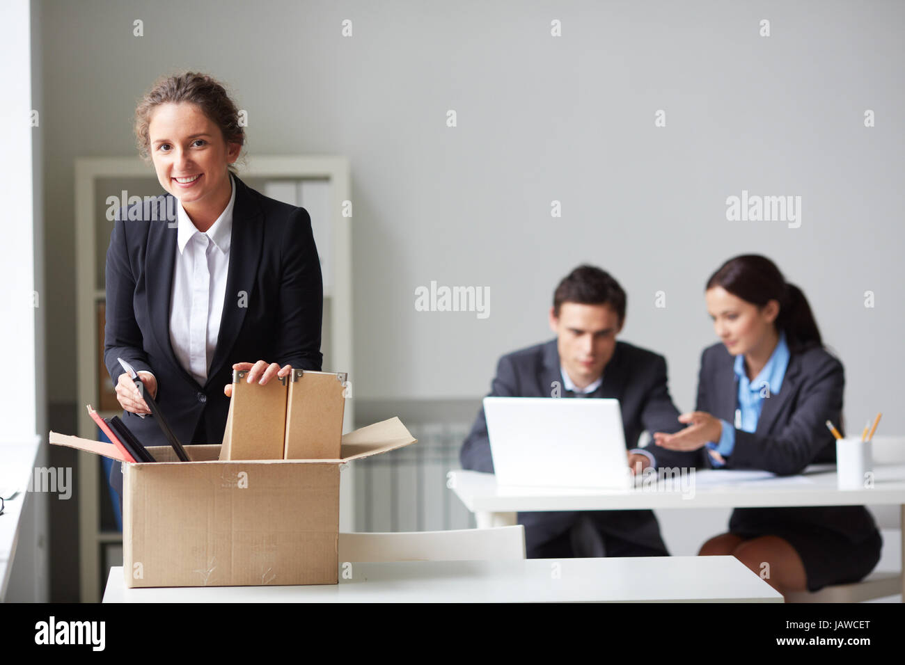 Portrait of smart businesswoman packing her things on background of ...