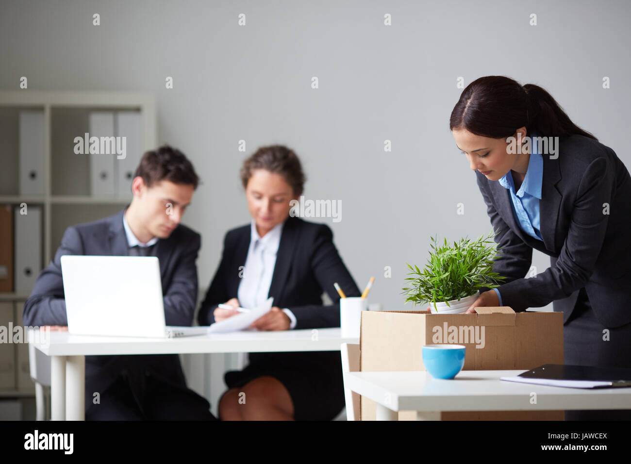 Portrait of smart businesswoman packing her things on background of ...