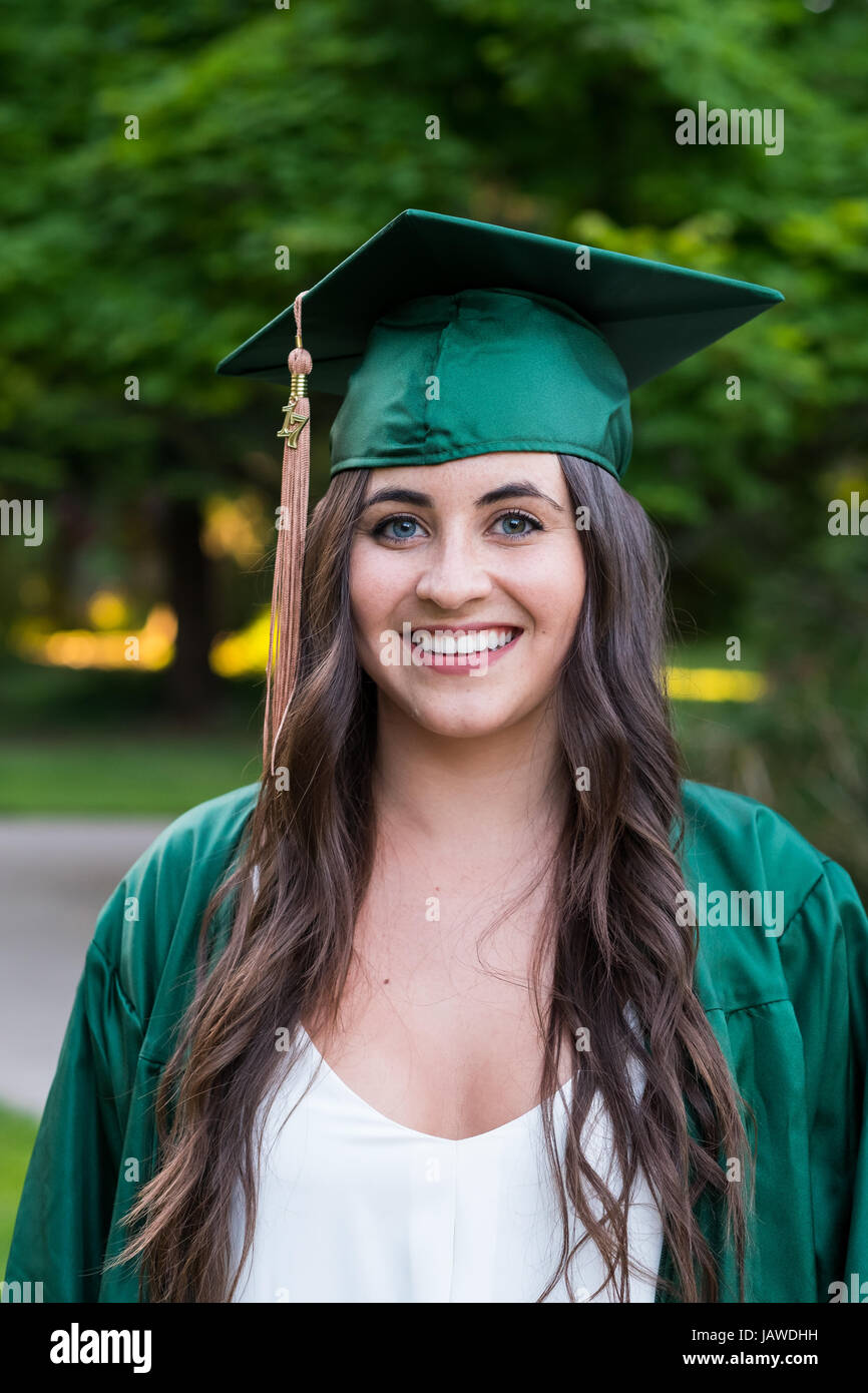 Pretty girl posing for a graduation photo on campus during her senior ...