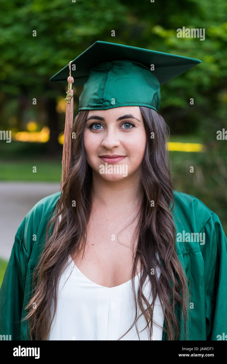 Pretty girl posing for a graduation photo on campus during her senior ...