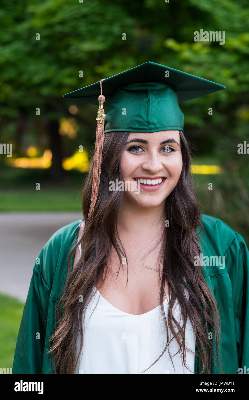 Pretty girl posing for a graduation photo on campus during her senior ...