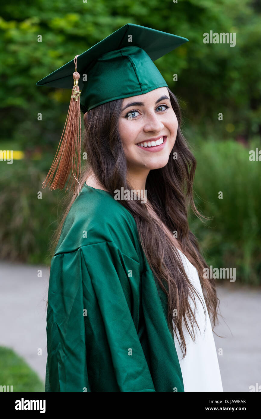 Pretty girl posing for a graduation photo on campus during her senior ...