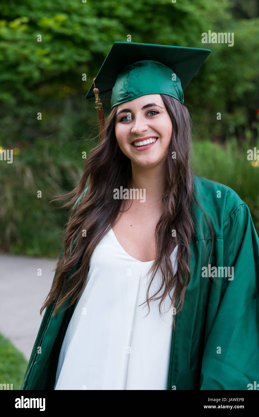 Pretty girl posing for a graduation photo on campus during her senior ...