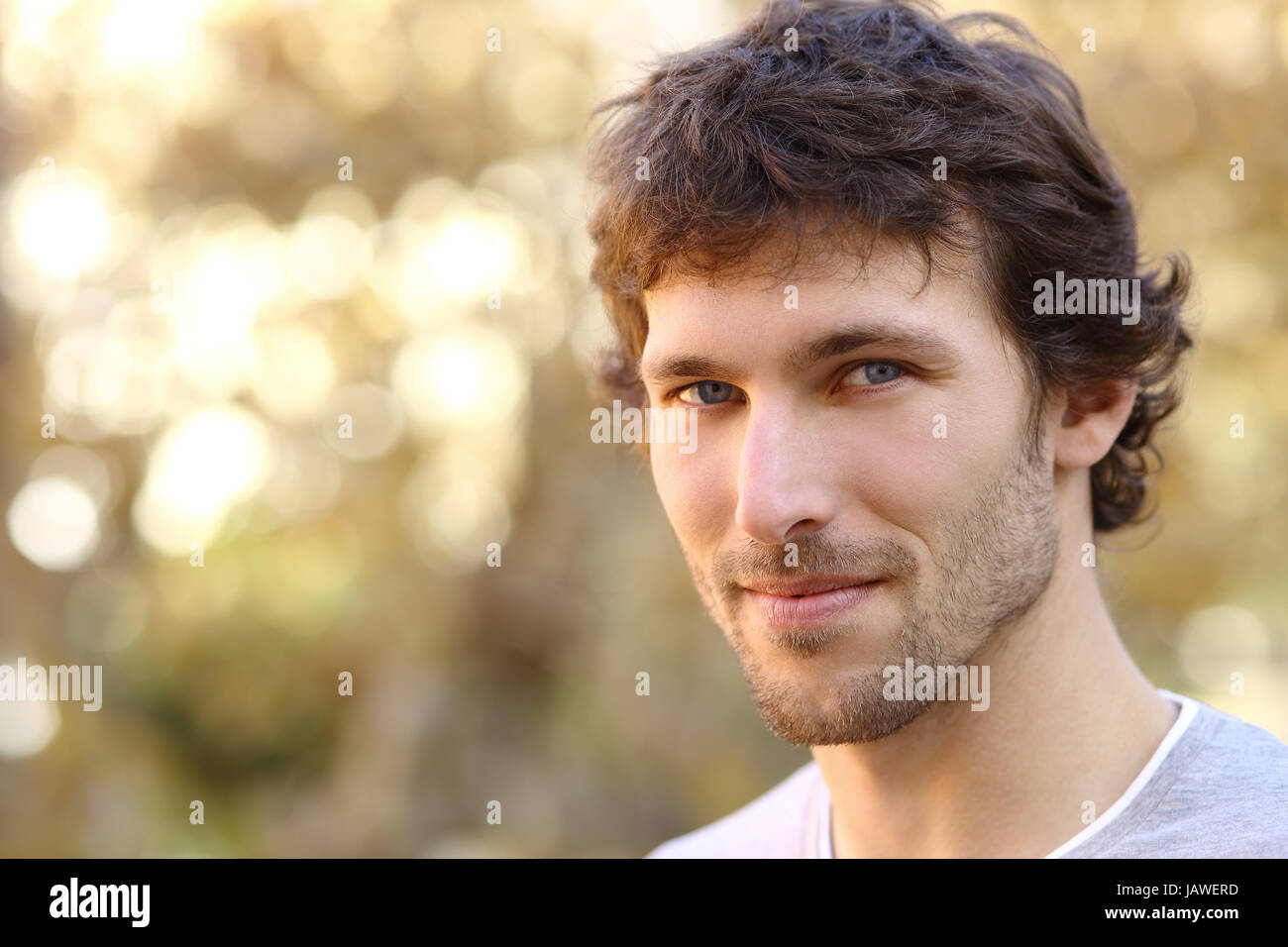Facial portrait of an attractive adult man with an unfocused warm ...