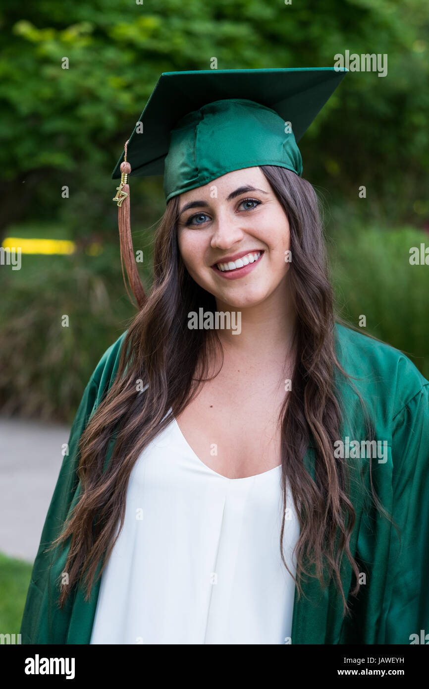 Pretty girl posing for a graduation photo on campus during her senior ...