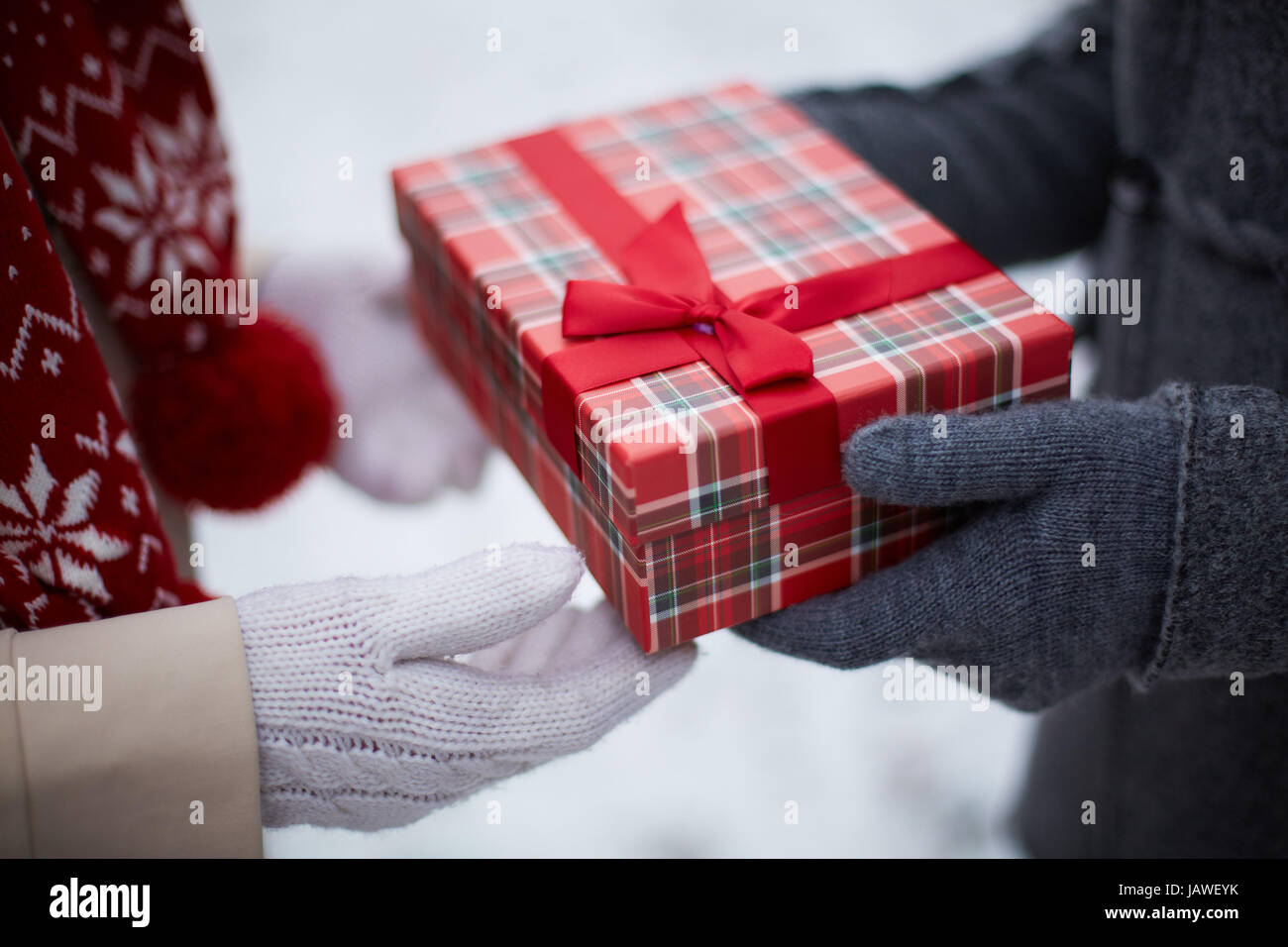 Image of gloved hand of guy giving his girlfriend Christmas present ...