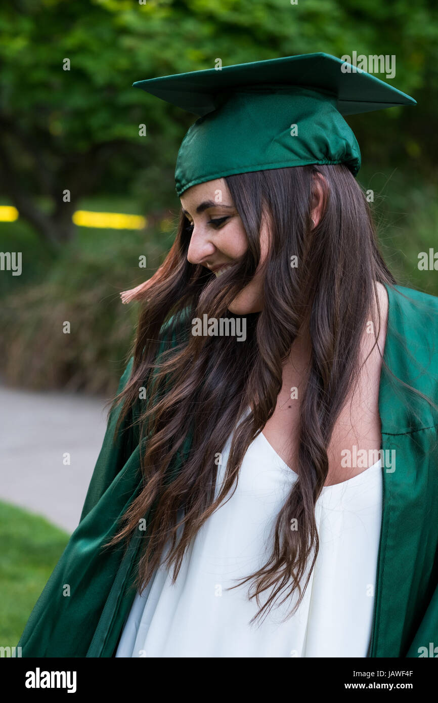 Pretty girl posing for a graduation photo on campus during her senior ...