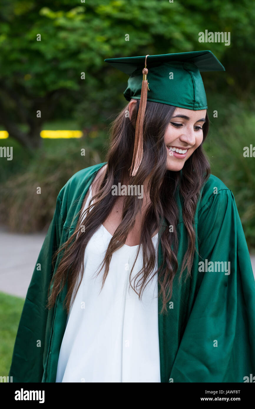 Pretty girl posing for a graduation photo on campus during her senior ...