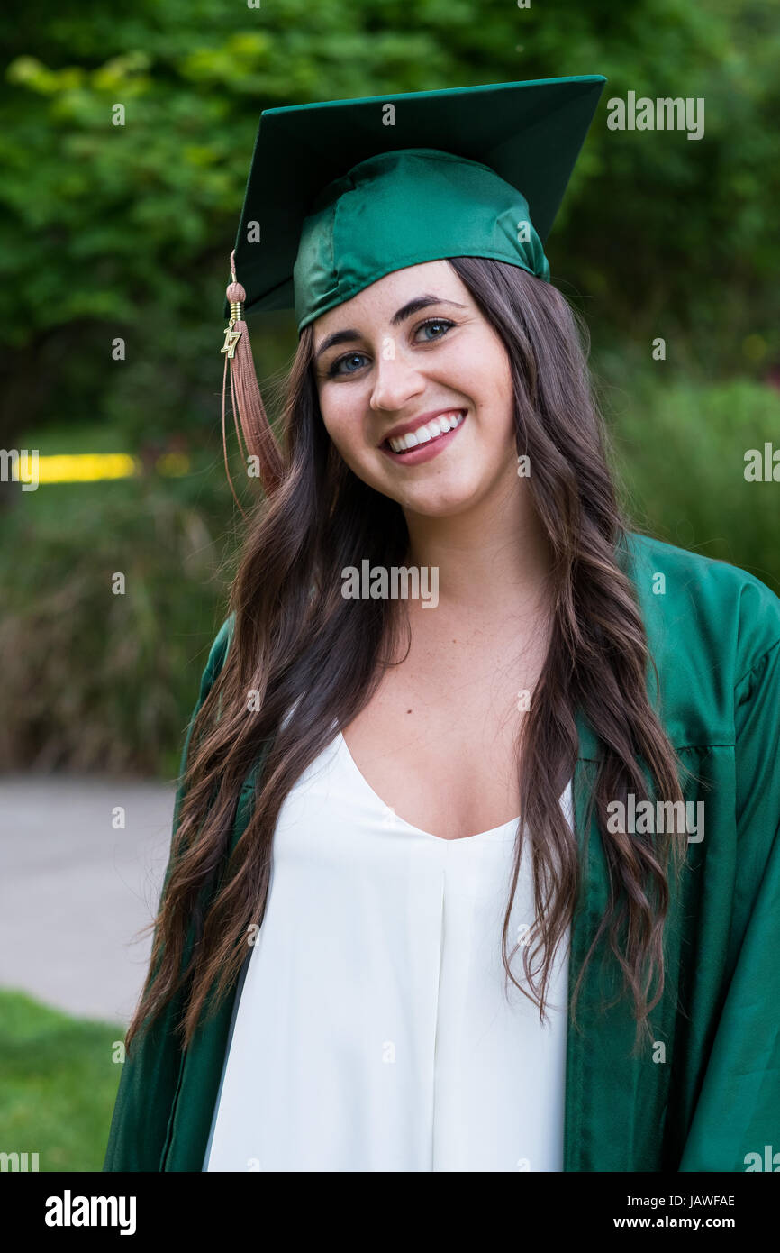 Pretty girl posing for a graduation photo on campus during her senior ...
