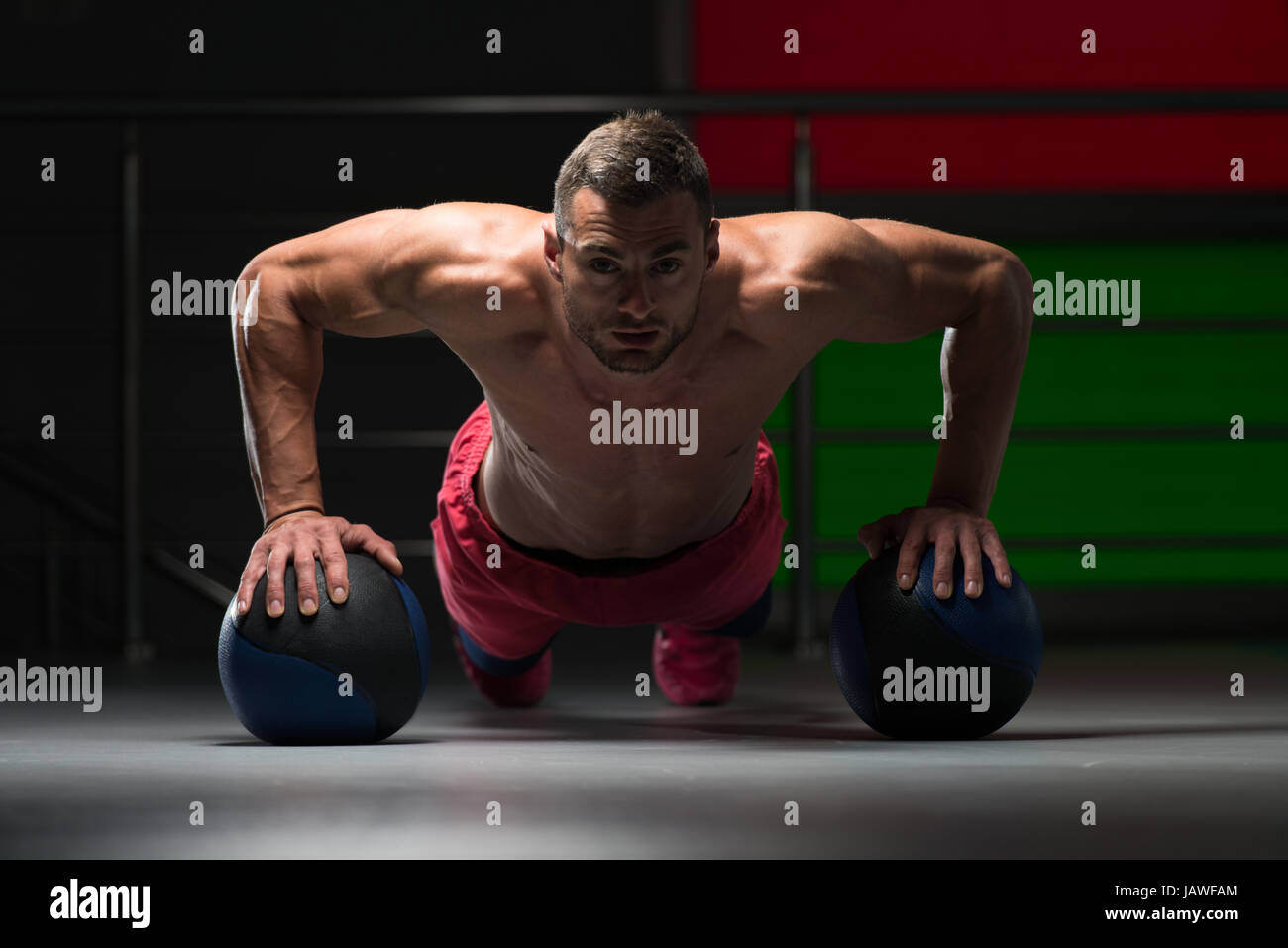 Handsome Young Man Doing Pushups With Medicine Ball As Part Of ...