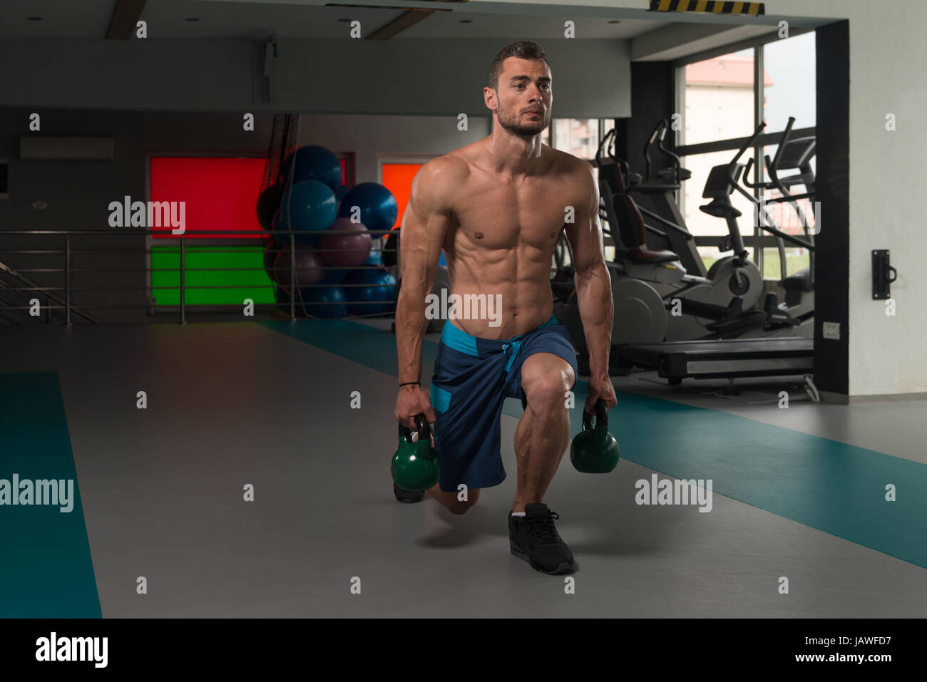 Young Man Working Out With Kettle Bell In A Dark Gym - Bodybuilder ...