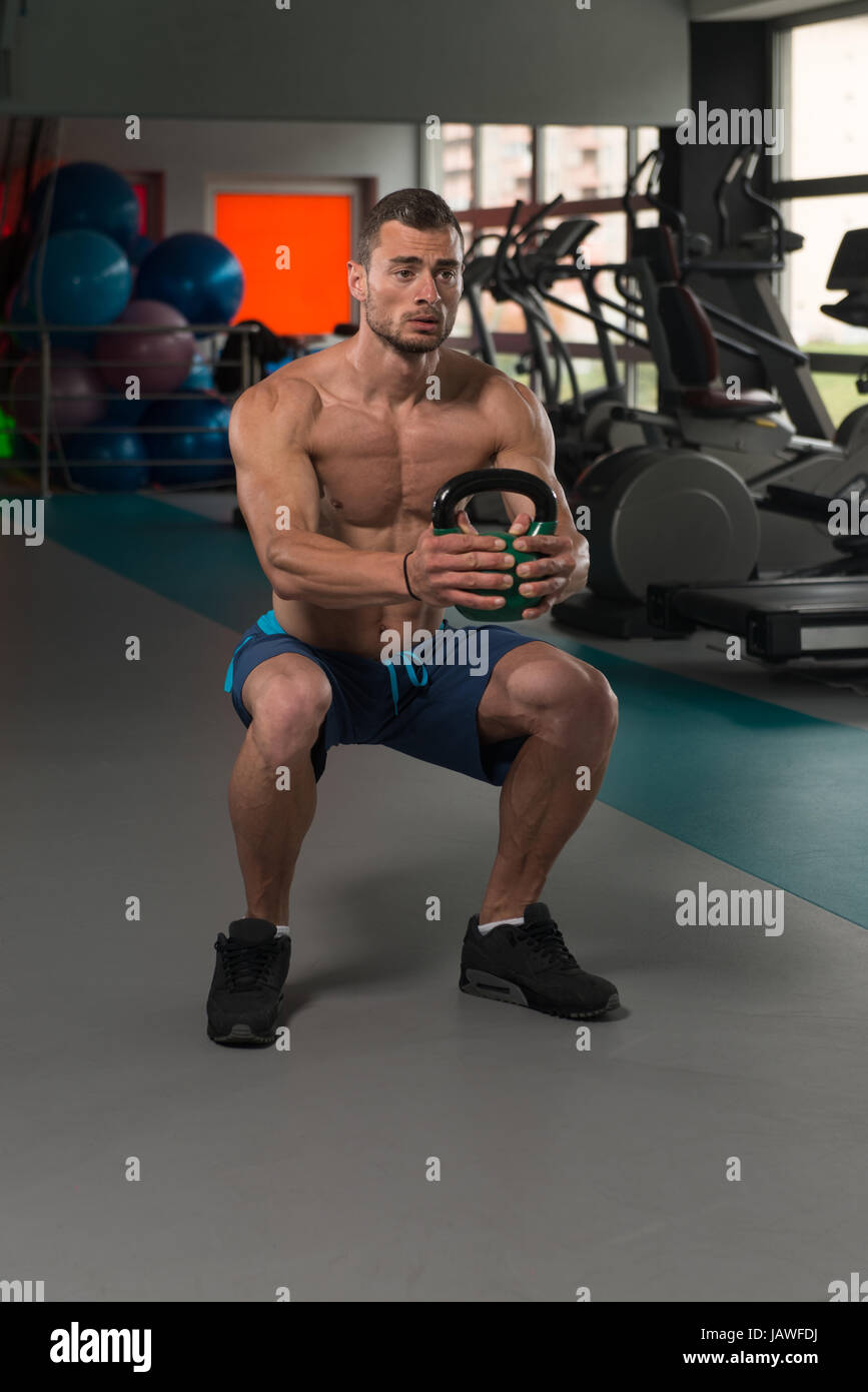 Young Man Exercising With Kettle Bell And Flexing Muscles - Muscular ...