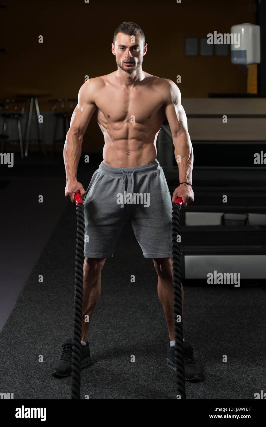 Battling Ropes Young Man At Gym Workout Exercise Stock Photo - Alamy