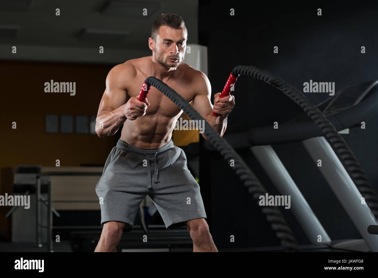 Battling Ropes Young Man At Gym Workout Exercise Stock Photo - Alamy
