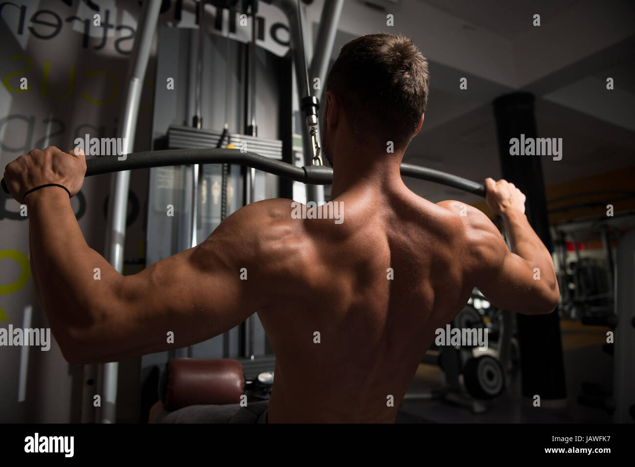 Handsome Bodybuilder Doing Heavy Weight Exercise For Back On Machine ...