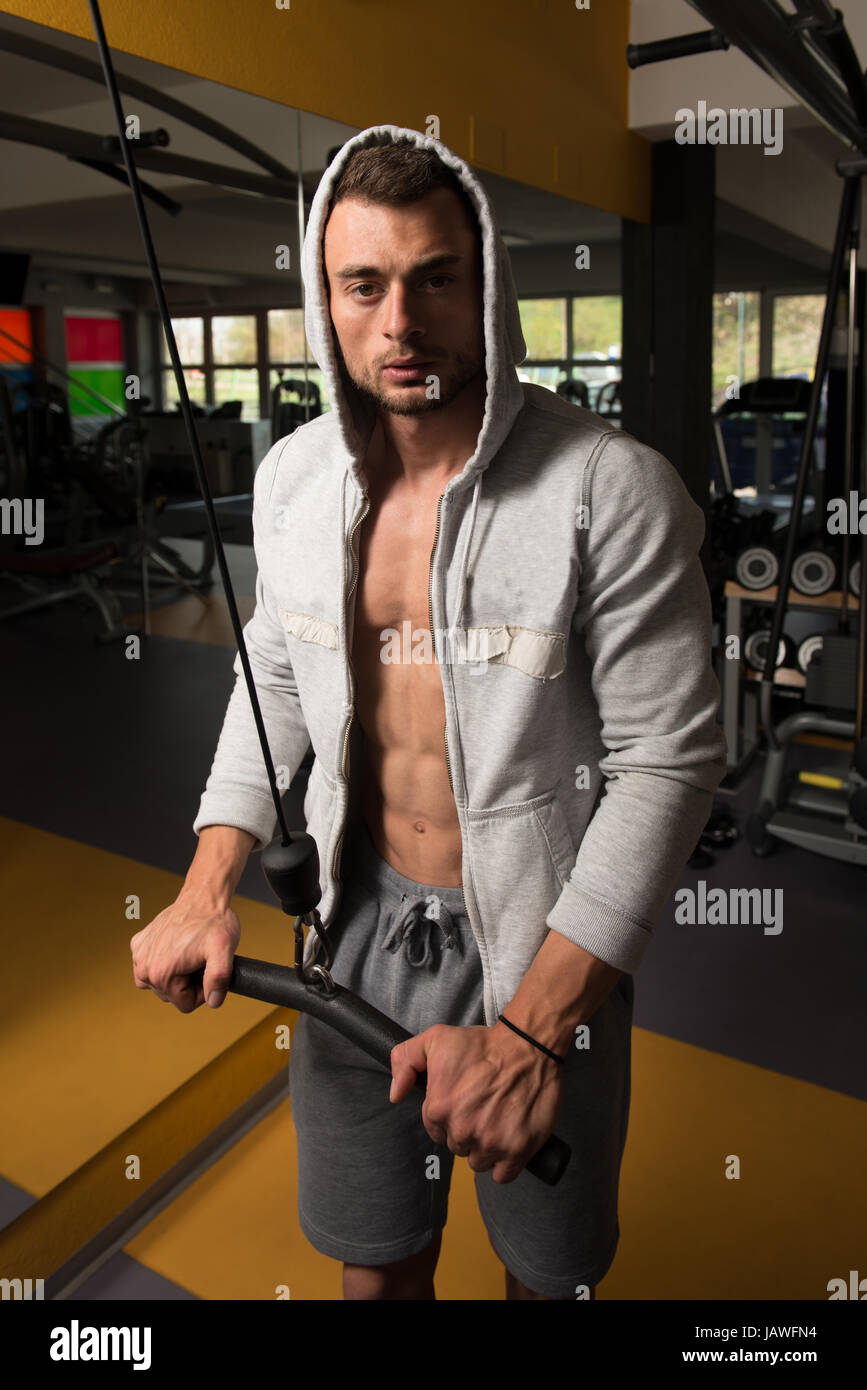 Man In The Gym Exercising On His Triceps On Machine With Cable In The ...