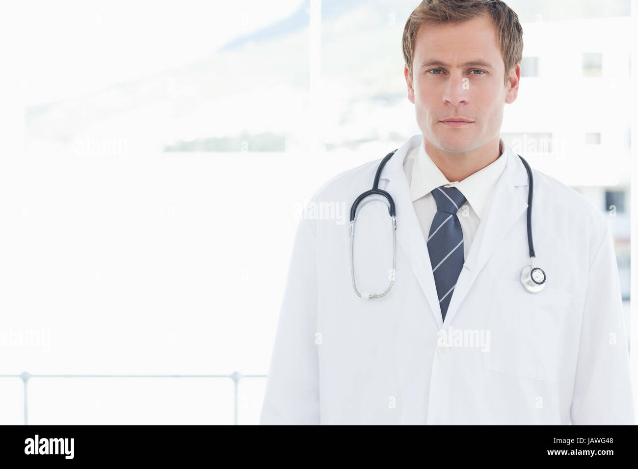 Doctor standing in front of a window Stock Photo - Alamy