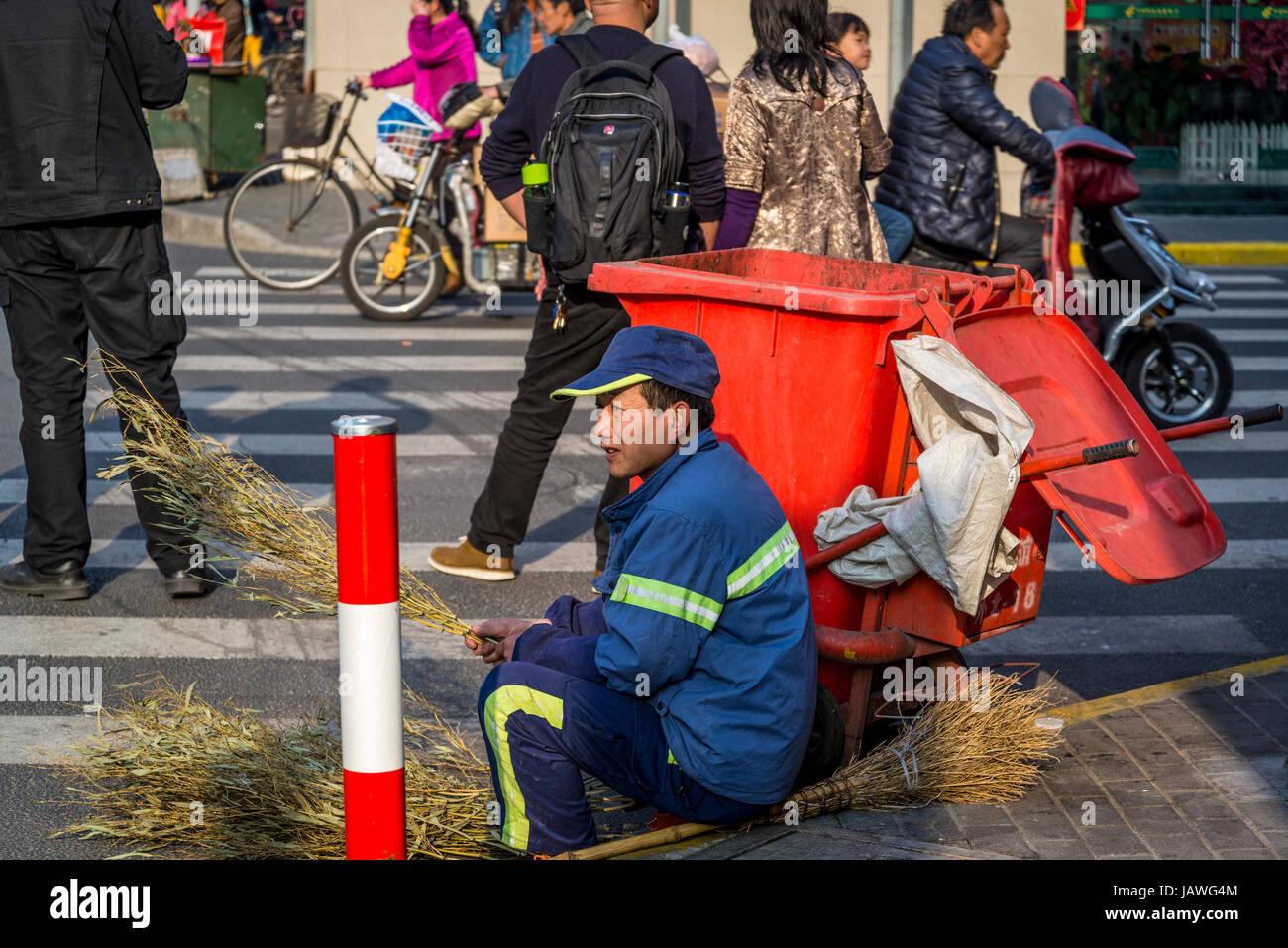 Street sweeper sitting in the road and sorting out his brooms, Shanghai ...