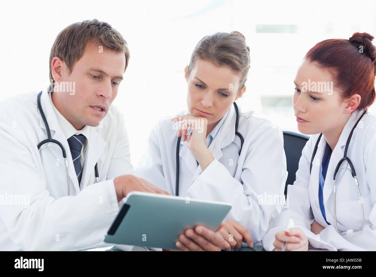 Doctor with tablet computer showing his colleagues something Stock ...