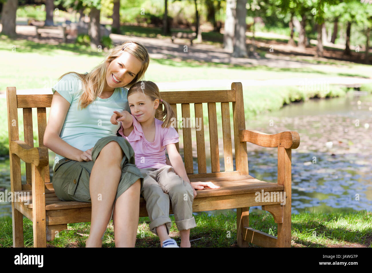 Mother and daughter sit on a bench Stock Photo - Alamy
