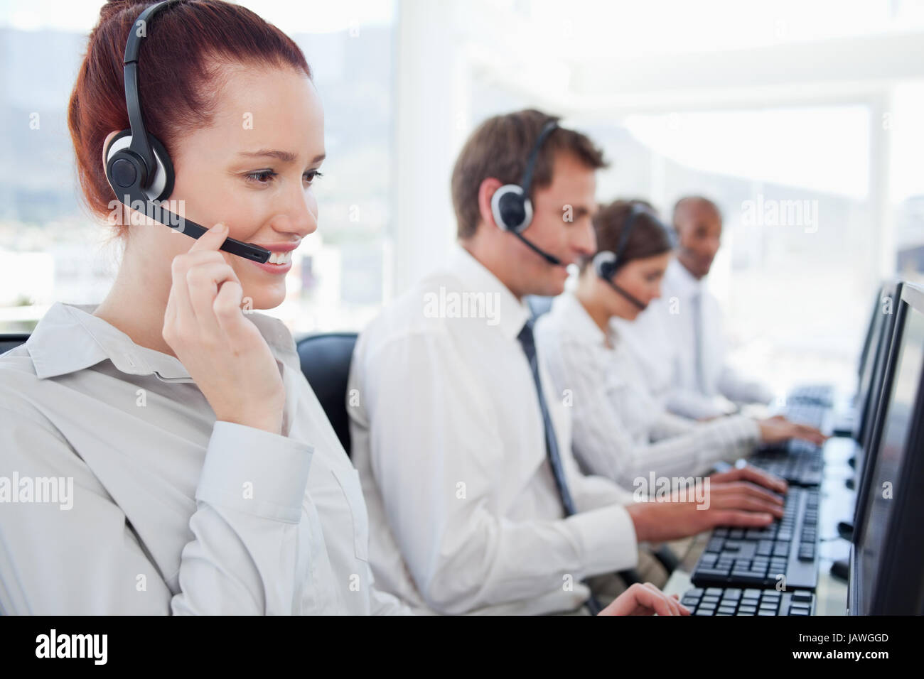Call center agents sitting in a line Stock Photo - Alamy