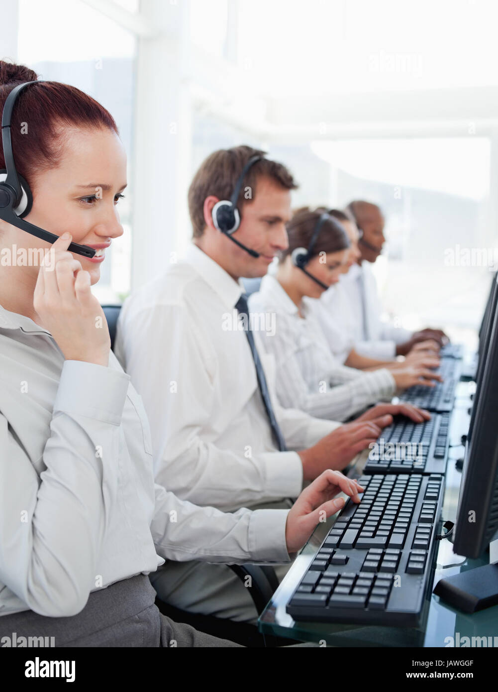 Call center employees sitting in a line Stock Photo - Alamy