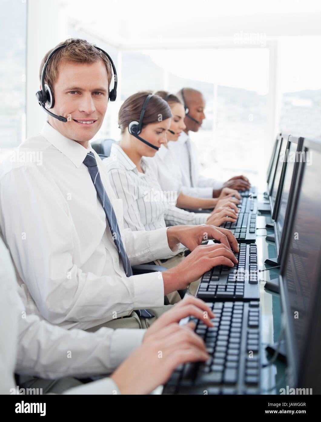 Call center agent sitting among his colleagues Stock Photo - Alamy